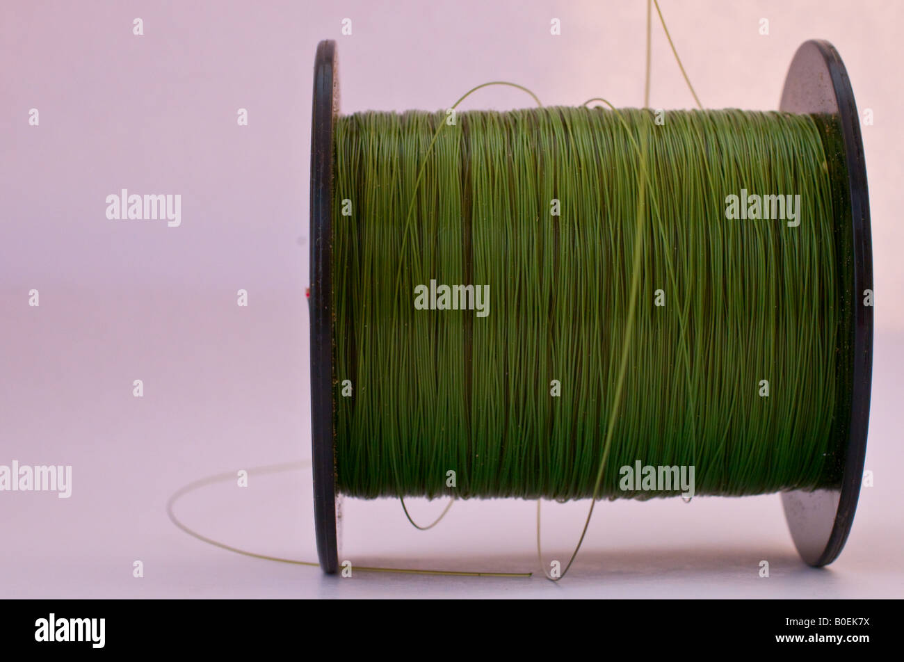 Old green fishing line on a black spool Stock Photo - Alamy