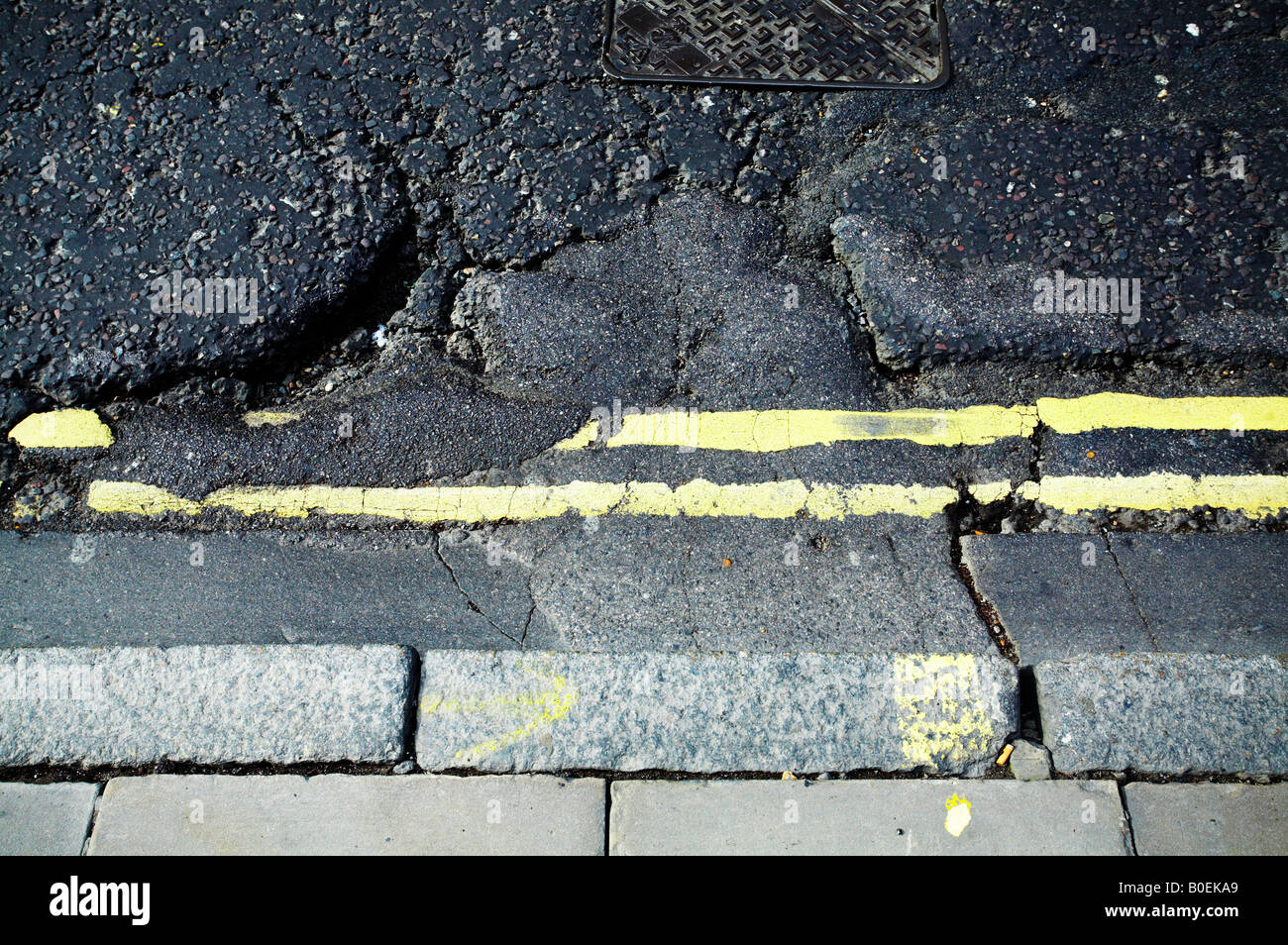 Cracked and broken tarmac road street in disrepair in London England UK ...