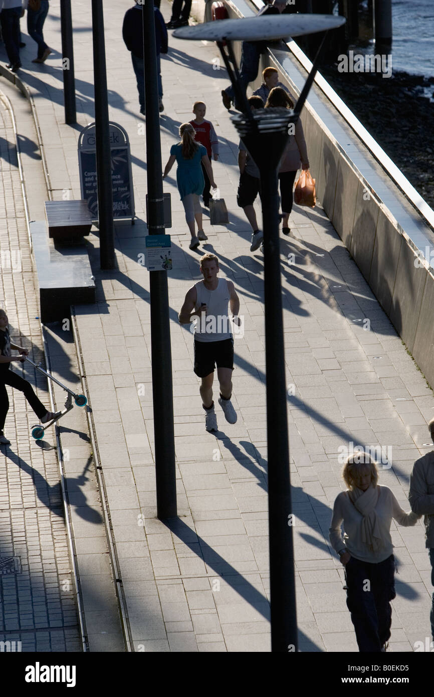 Pedestrians and jogger on Thames Path South Bank London England United ...