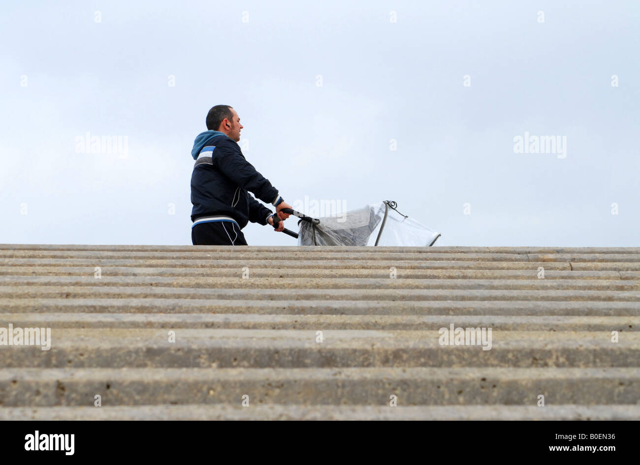 Abstract view across the steps of a man pushing a pram Stock Photo - Alamy