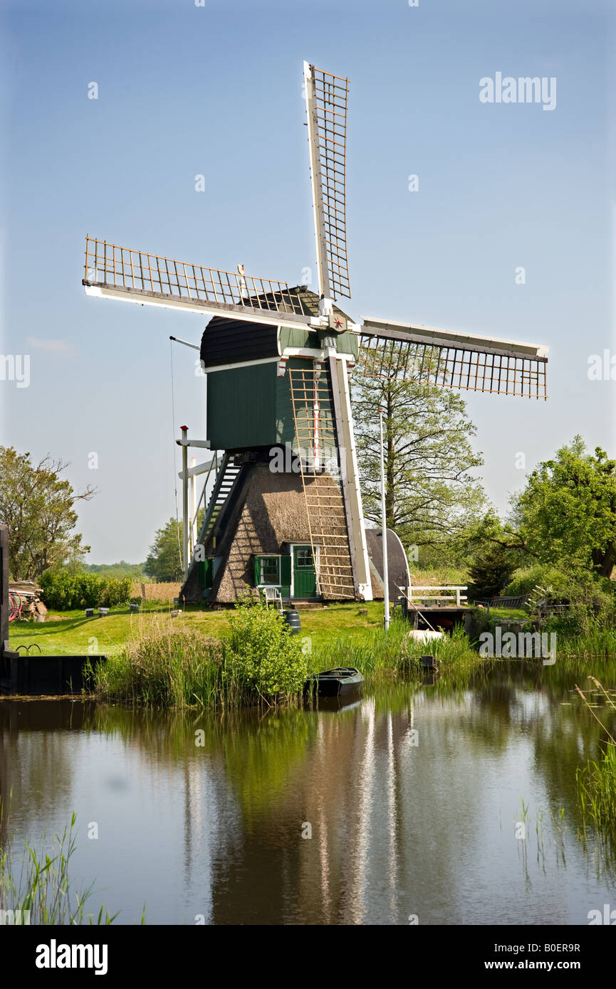 A dutch windmill on the shores of a river Stock Photo - Alamy