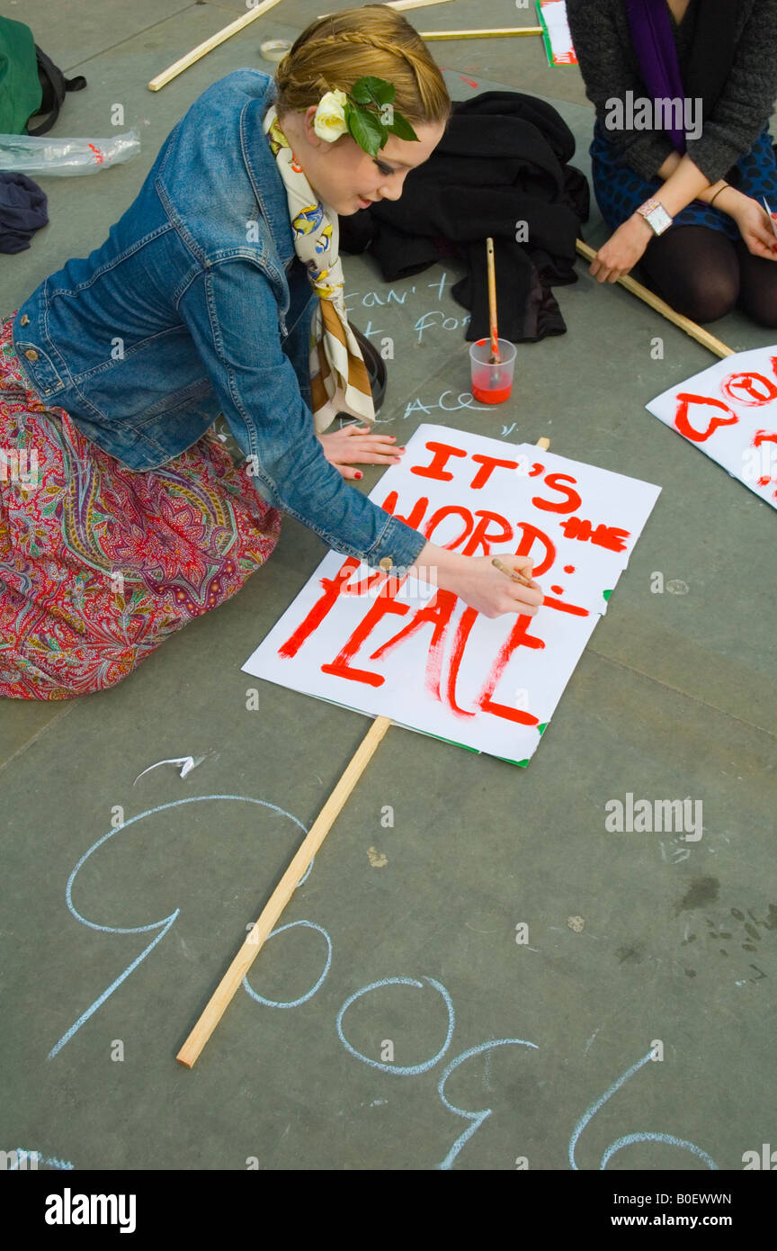 Girl painting a banner at a peace rally at Trafalgar Square in London ...
