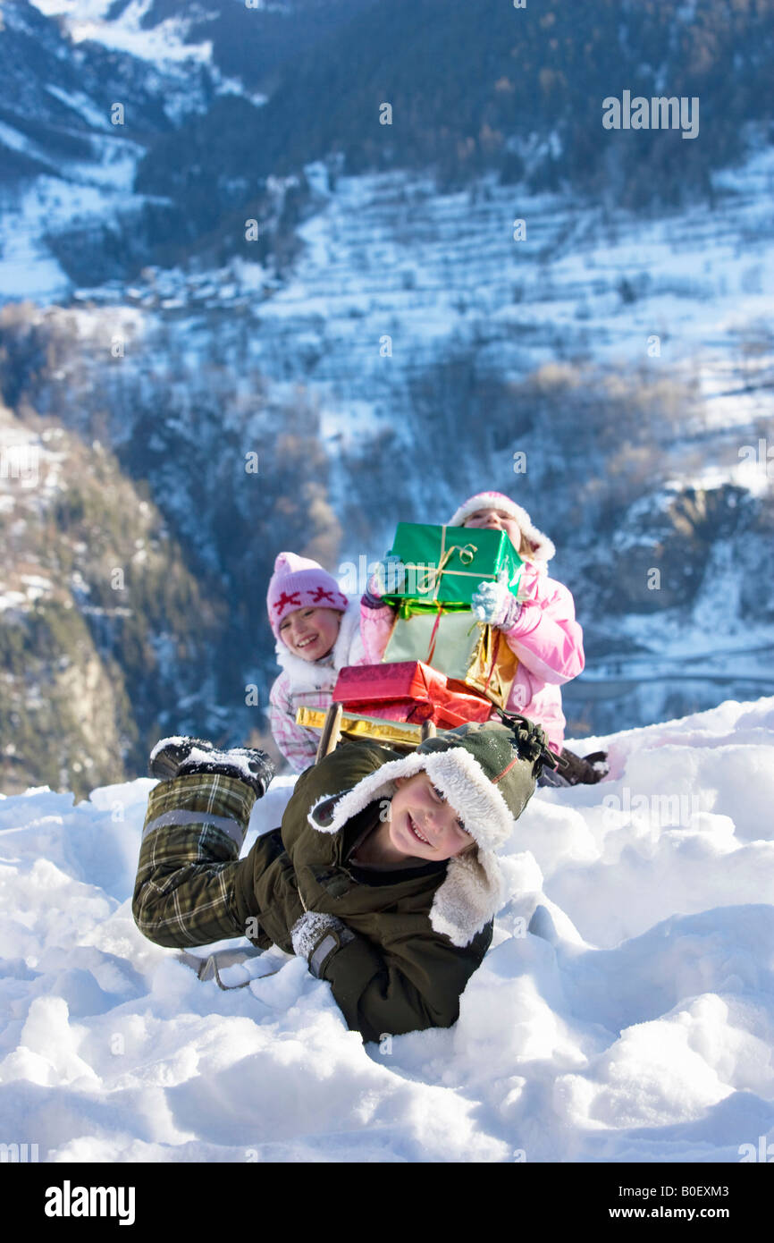 Children playing in snow with presents Stock Photo - Alamy