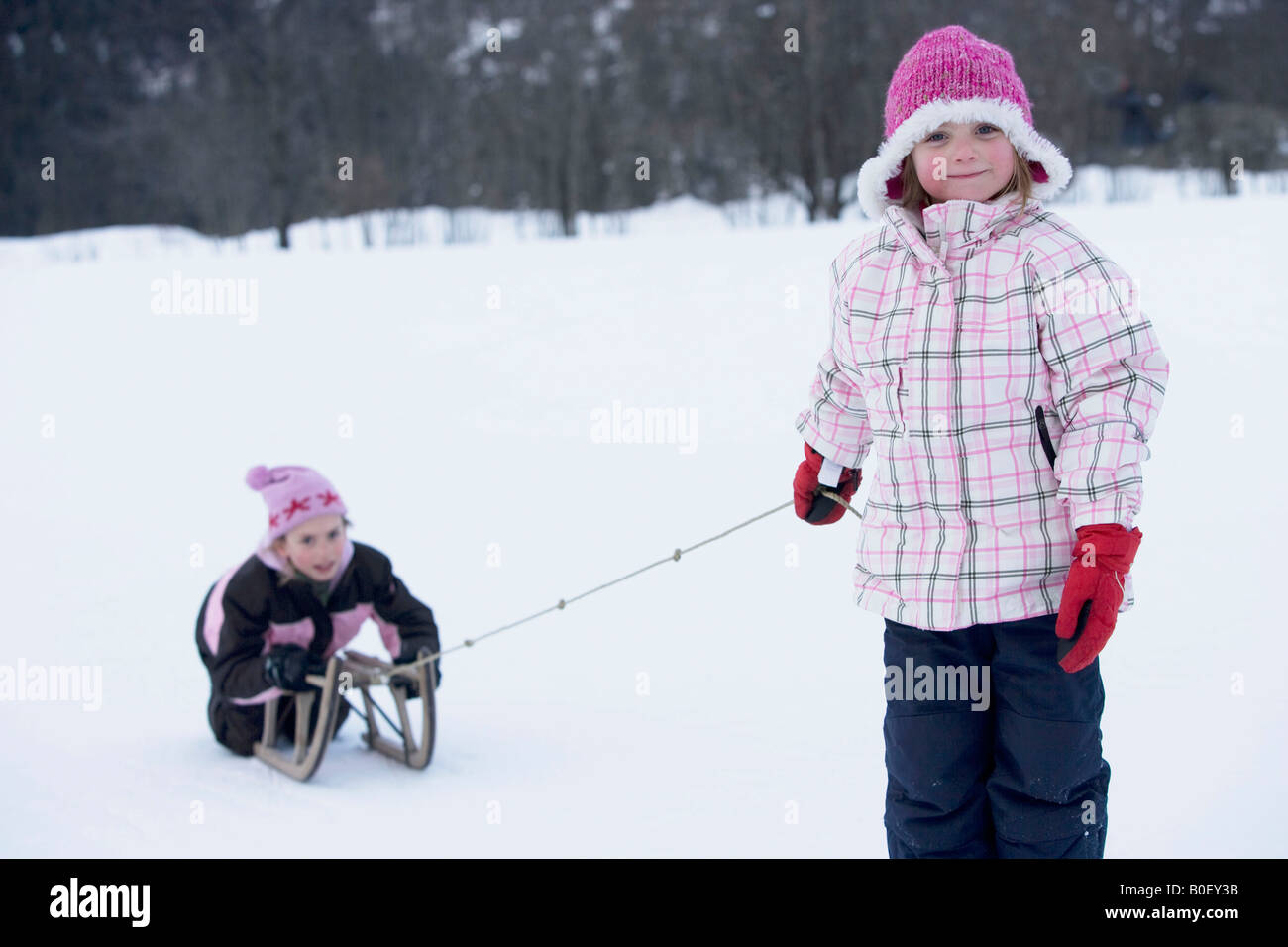 Young girls playing with sledge Stock Photo - Alamy