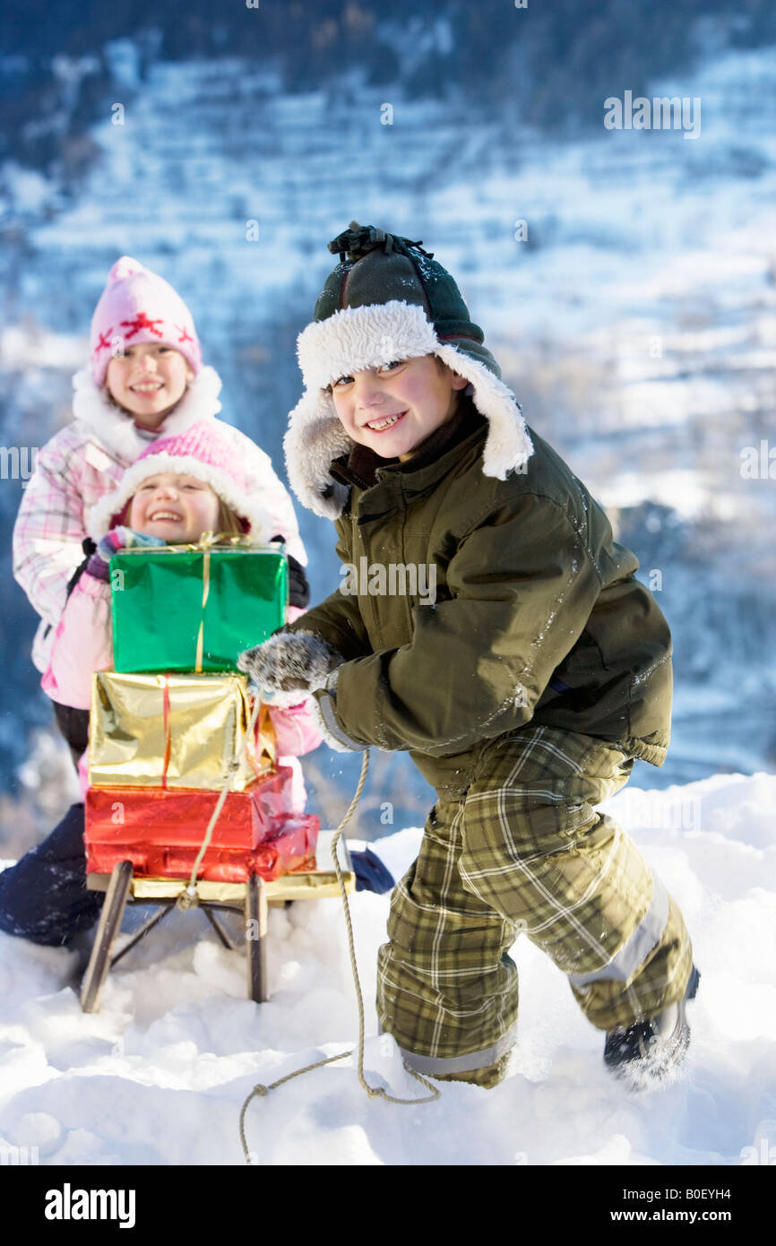 Children playing in snow with presents Stock Photo - Alamy