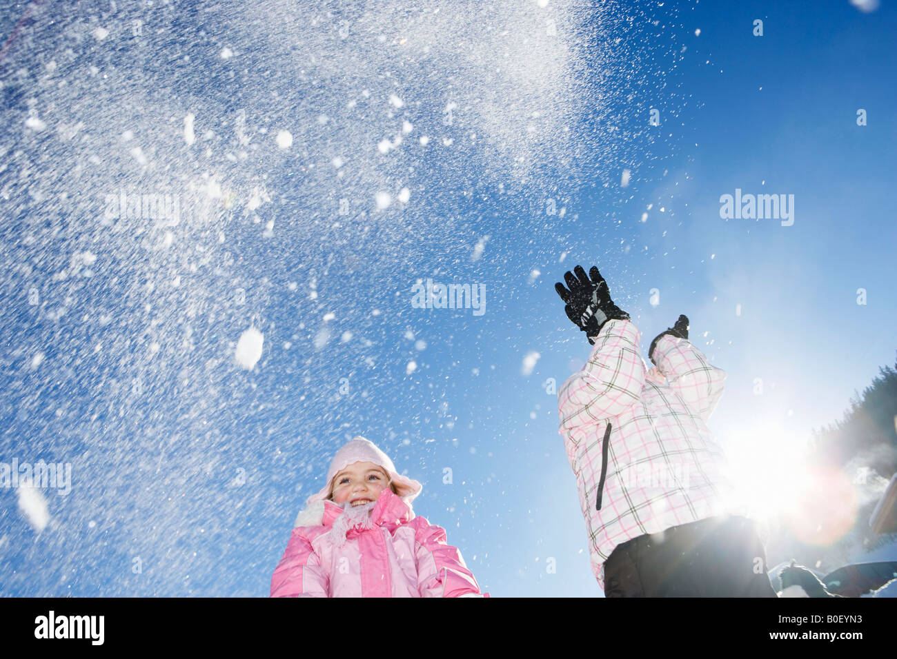 Young girls throwing snow in the air Stock Photo - Alamy