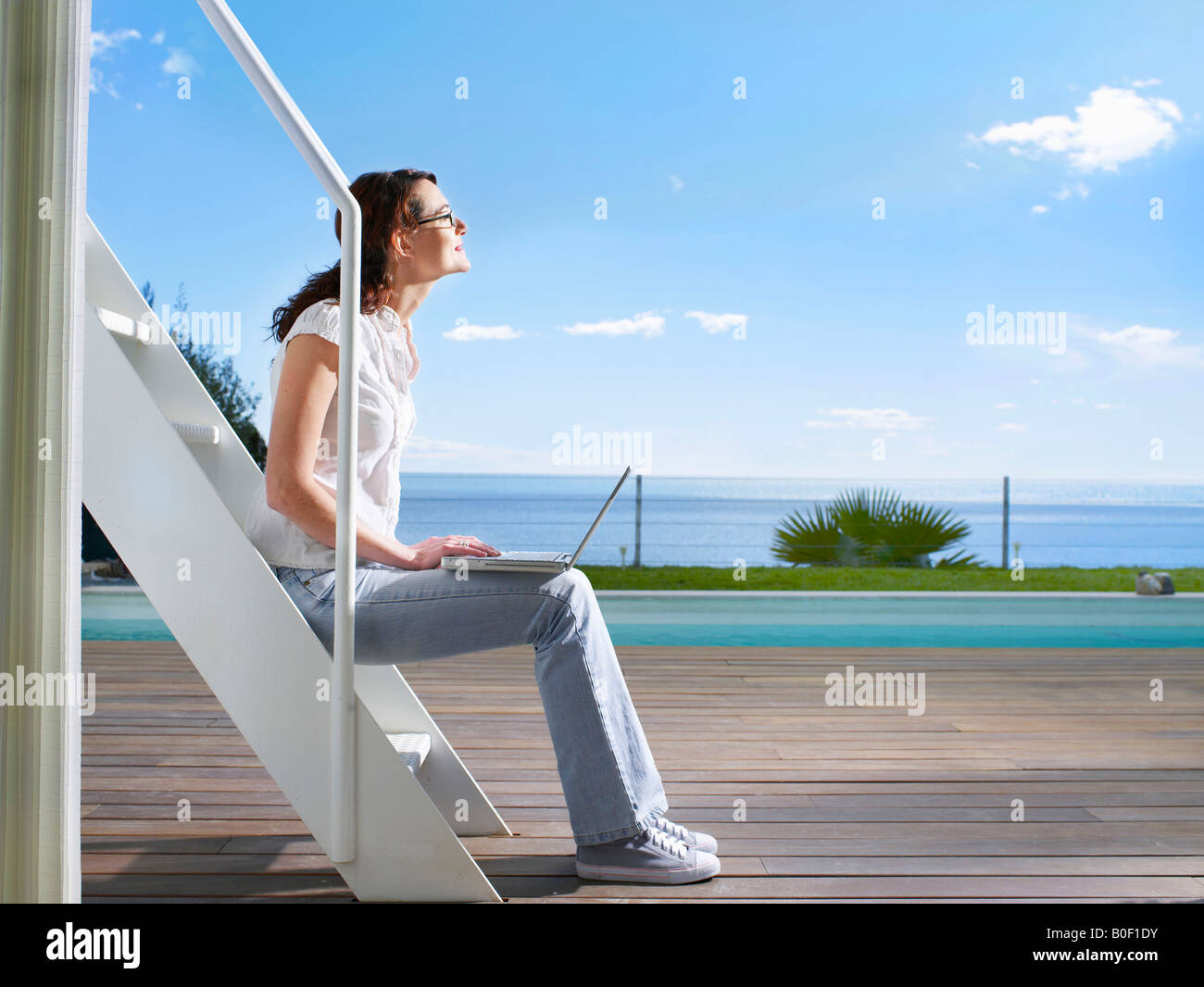 Female sitting outside with laptop Stock Photo - Alamy