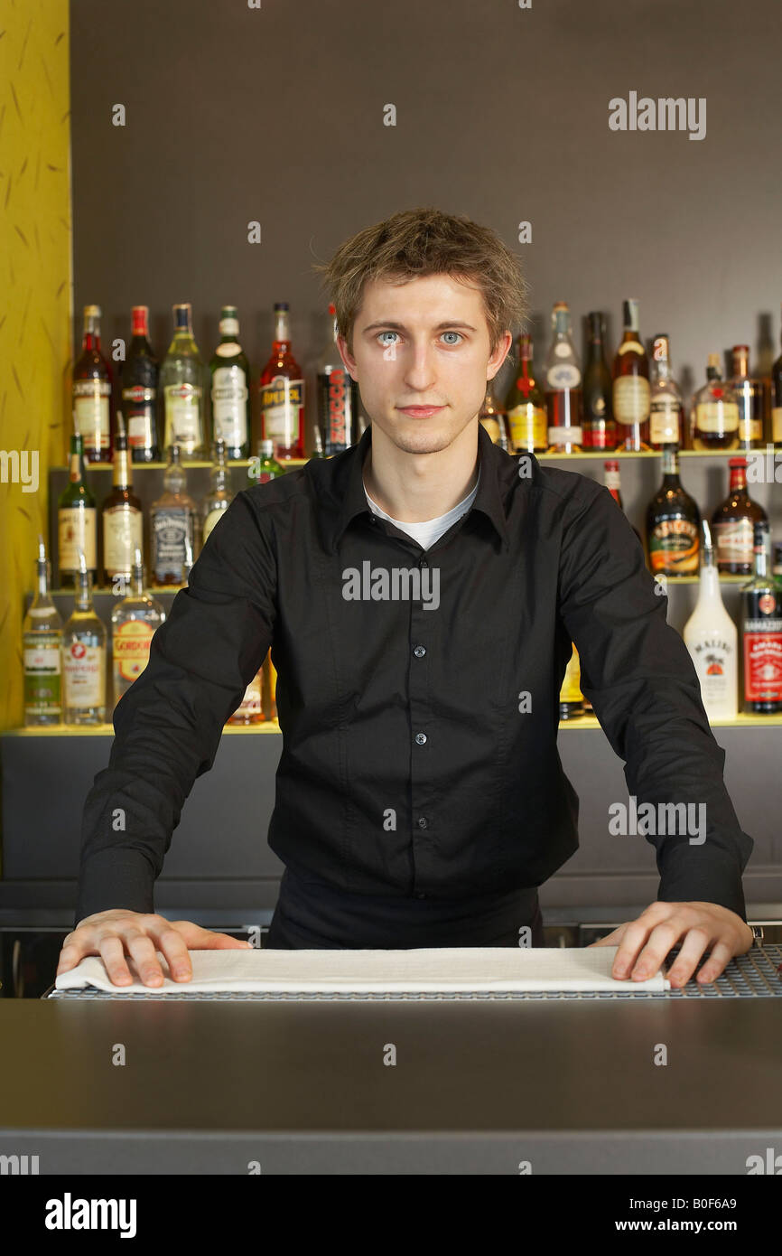 Portrait of young barman behind his bar Stock Photo - Alamy