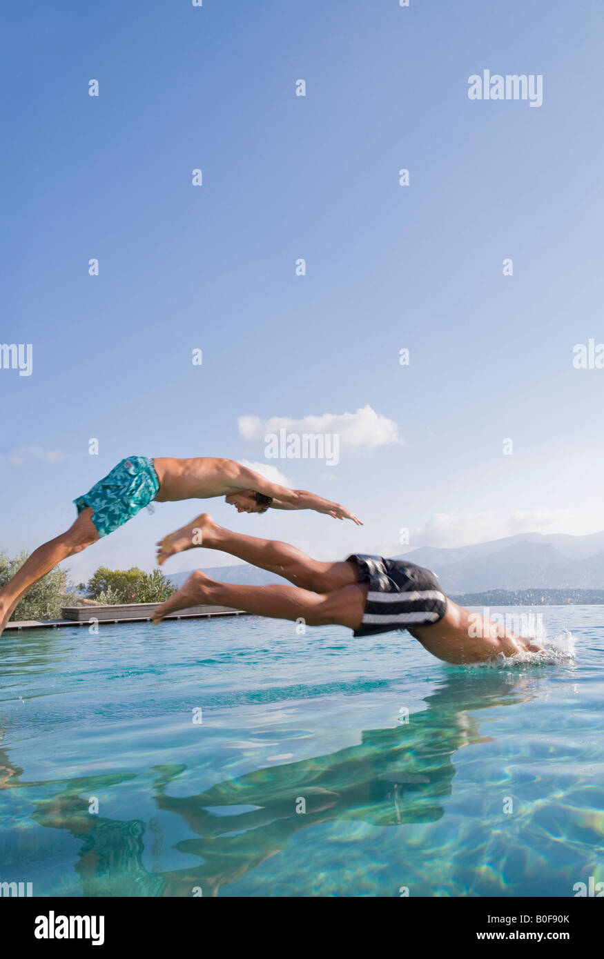 Young men diving into a pool Stock Photo - Alamy