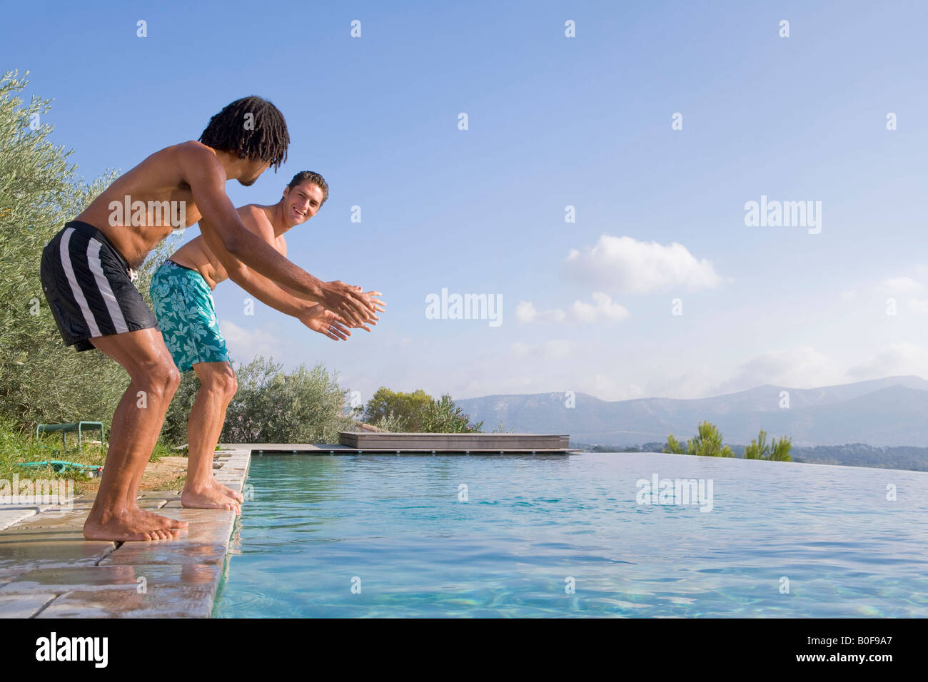 Two men jumping swimming pool hi-res stock photography and images - Alamy