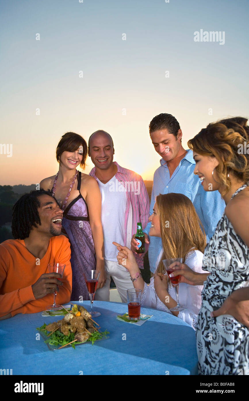 Young people having dinner at sunset Stock Photo - Alamy