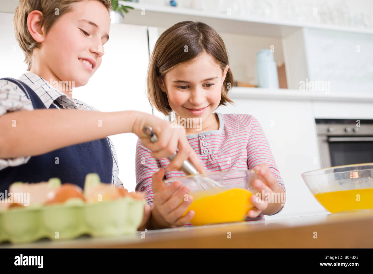 Boy and girl stirring egg yolk together Stock Photo - Alamy