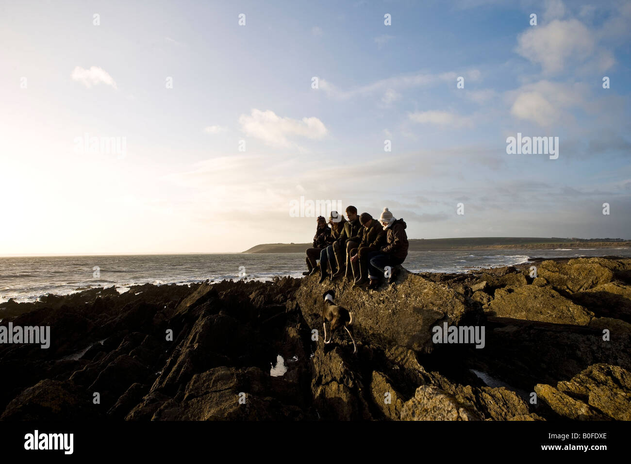 Group of Friends sitting on rock Stock Photo - Alamy