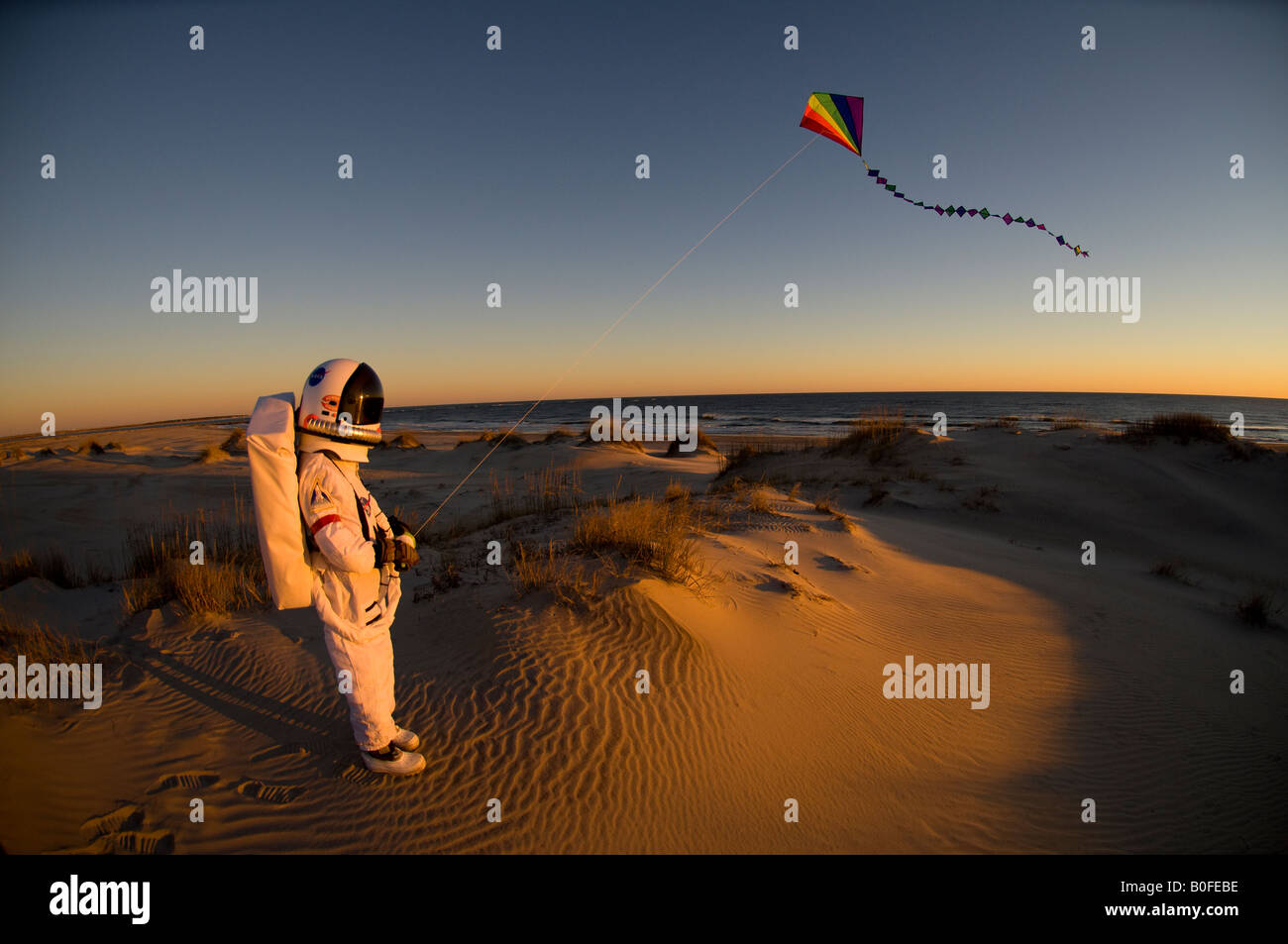 Kid in a space suit flying a kite Stock Photo - Alamy