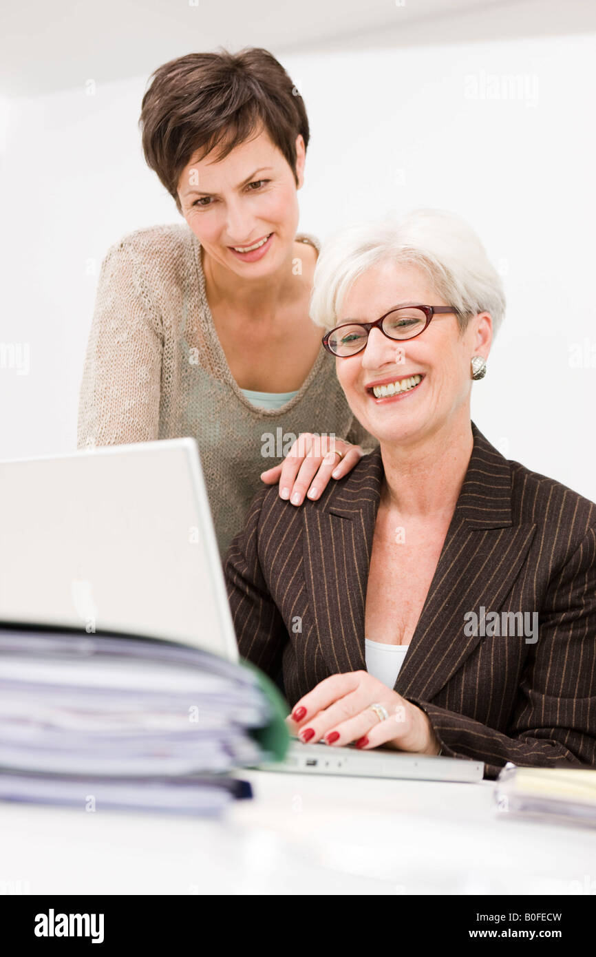 Two women working together at a pc Stock Photo - Alamy