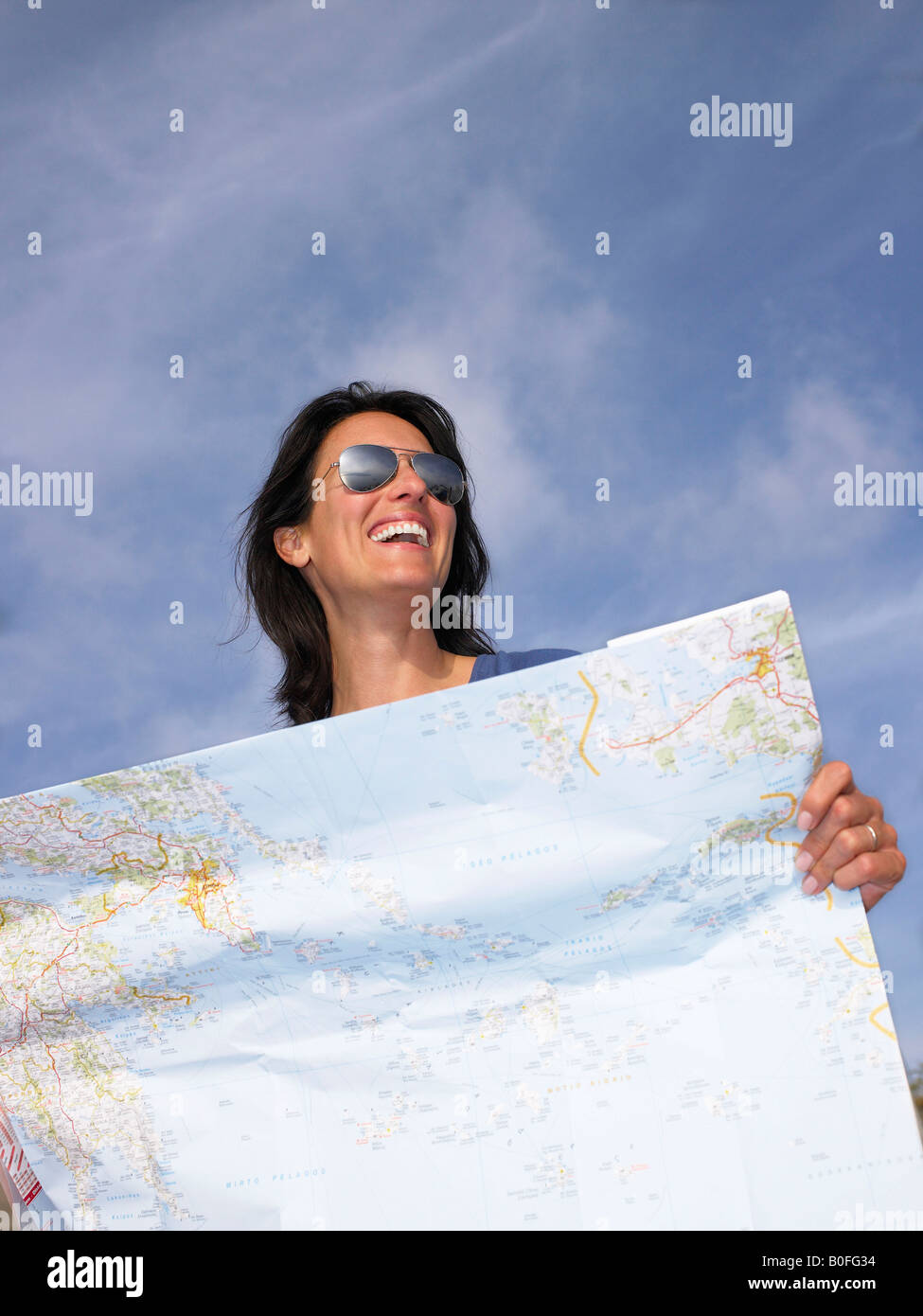 Woman looking at a map, laughing Stock Photo - Alamy