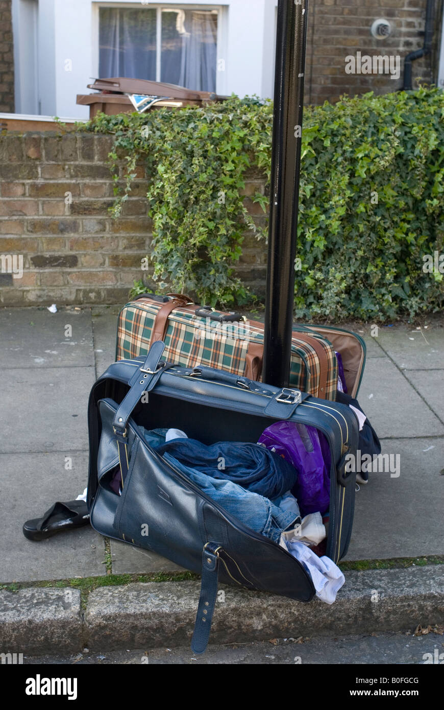 London UK April 2008 Dumped suitcase and clothes in the street Stock ...