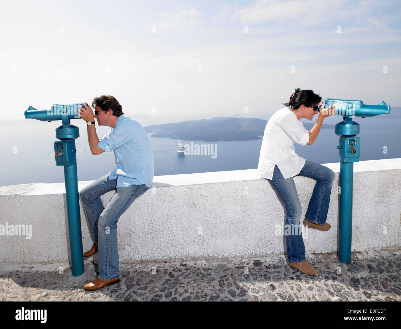 Couple looking through spyglasses Stock Photo - Alamy