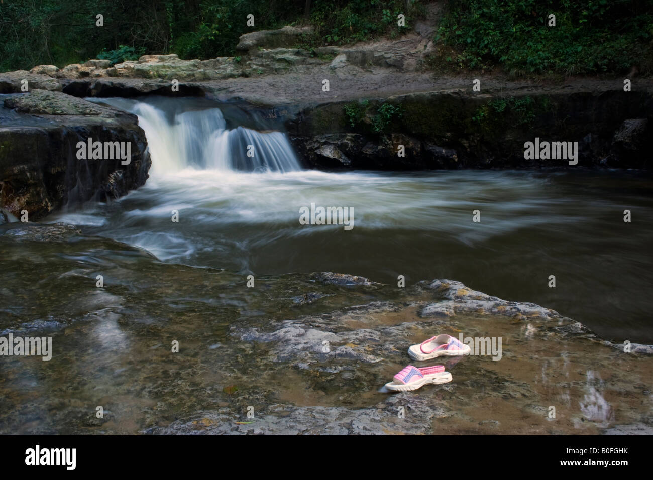 Flip flops placed on rock outcrop by waterfall Stock Photo - Alamy