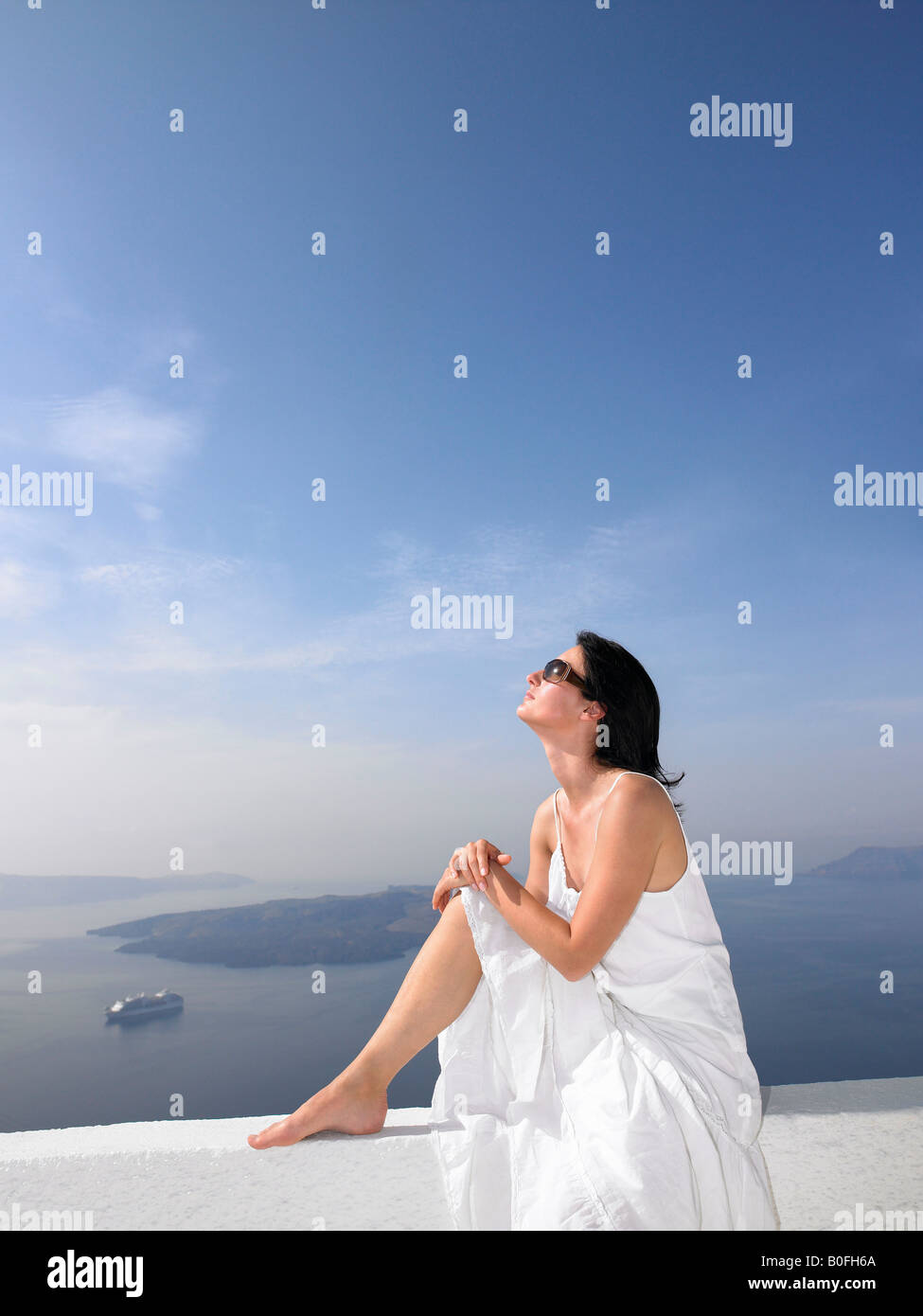 Woman resting on a white wall Stock Photo - Alamy