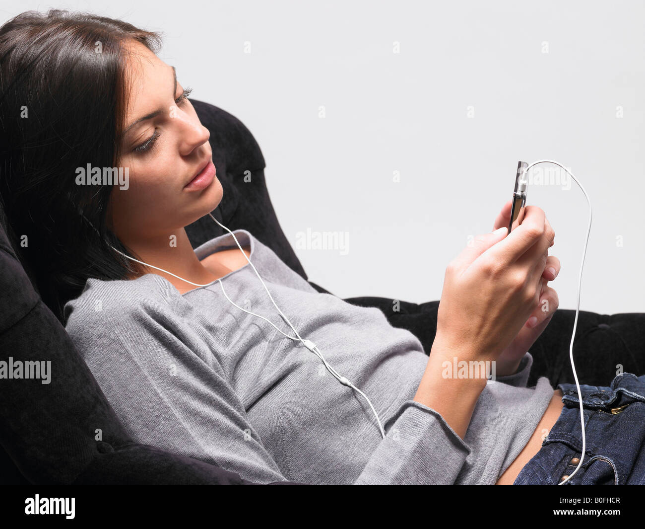 Woman listening to music on mp3 player Stock Photo - Alamy