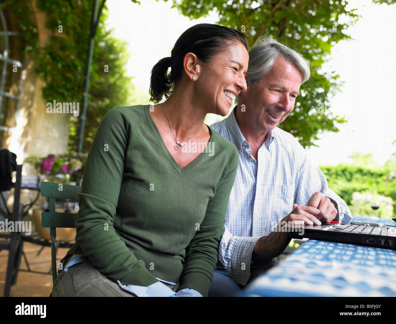 Couple on computer, laughing Stock Photo - Alamy