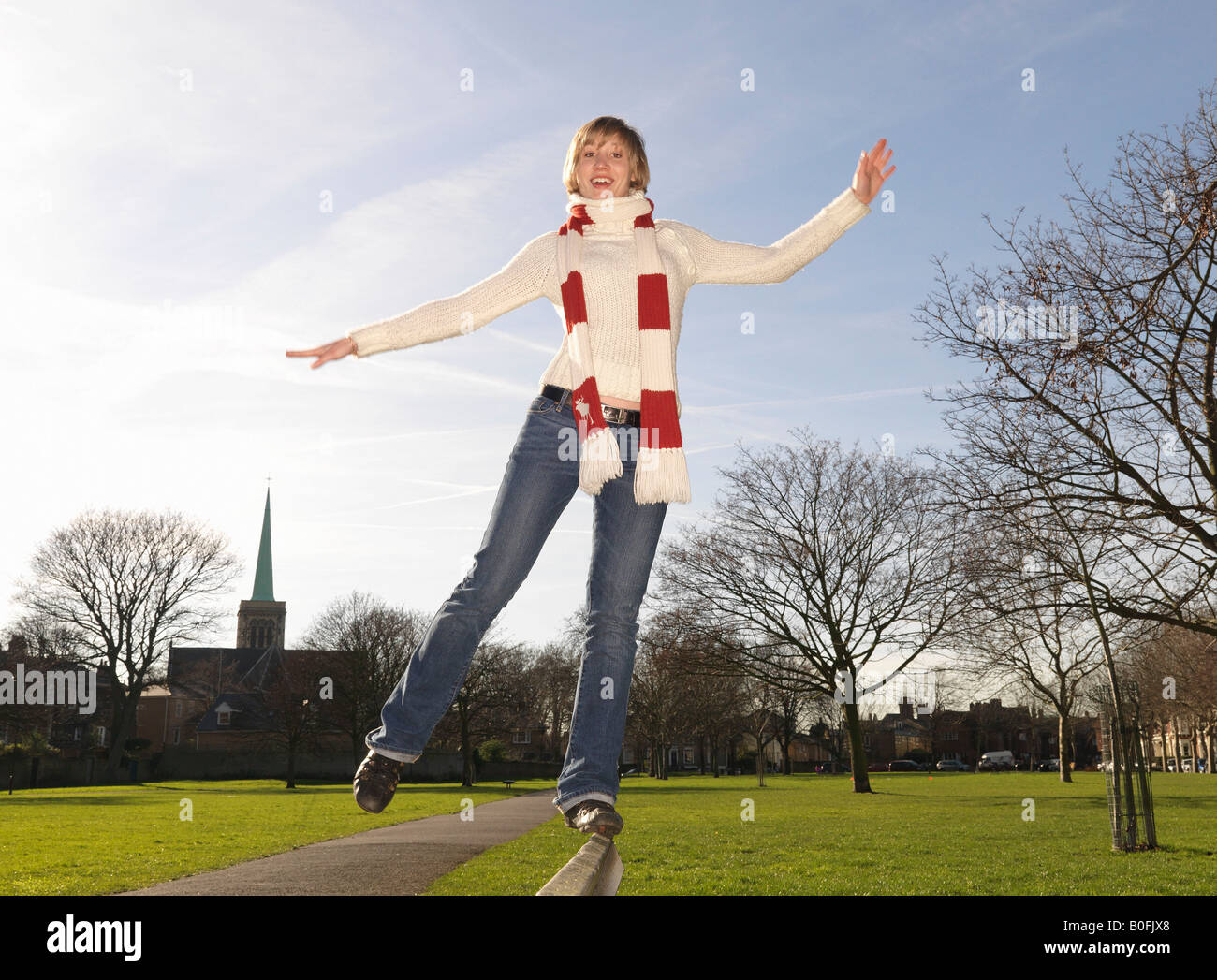 Woman balancing on bench in park Stock Photo - Alamy