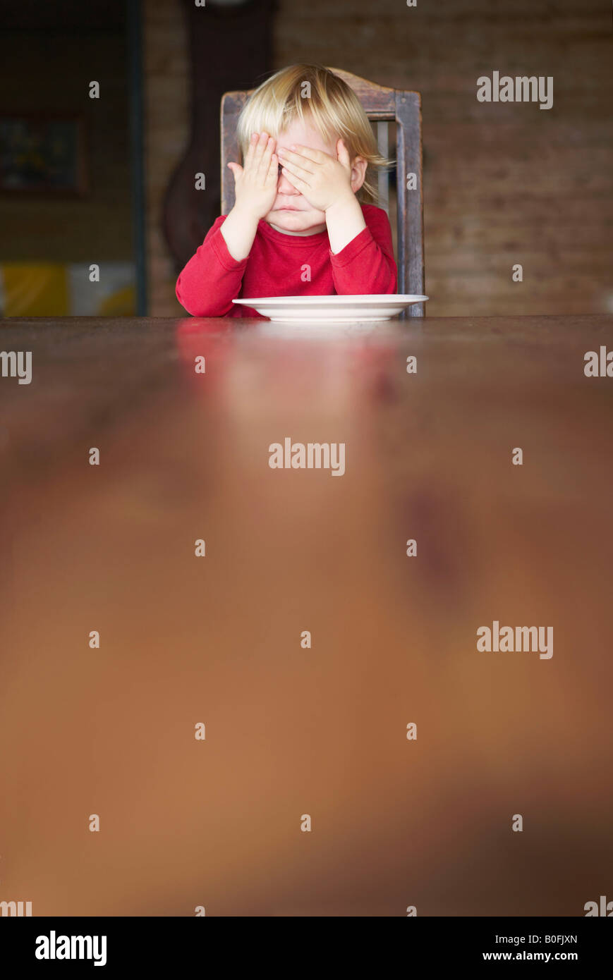 Boy covering face with hands Stock Photo - Alamy