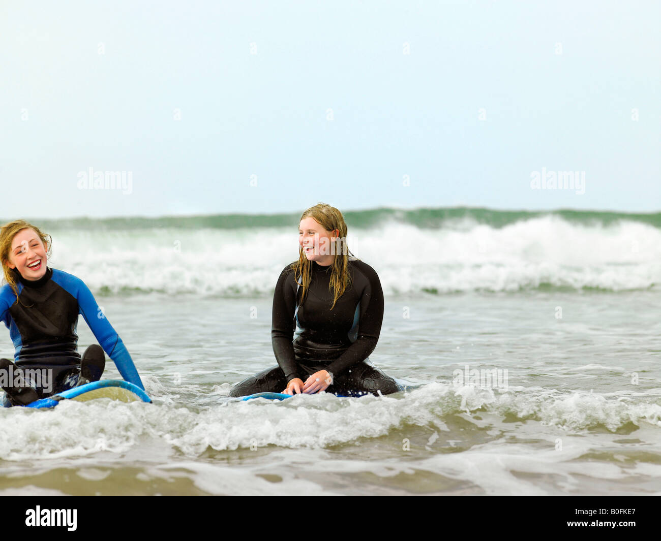 Female surfers sitting on surfboards Stock Photo - Alamy