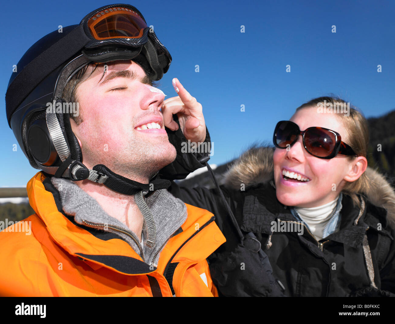 Young woman putting sunscreen on friend Stock Photo - Alamy