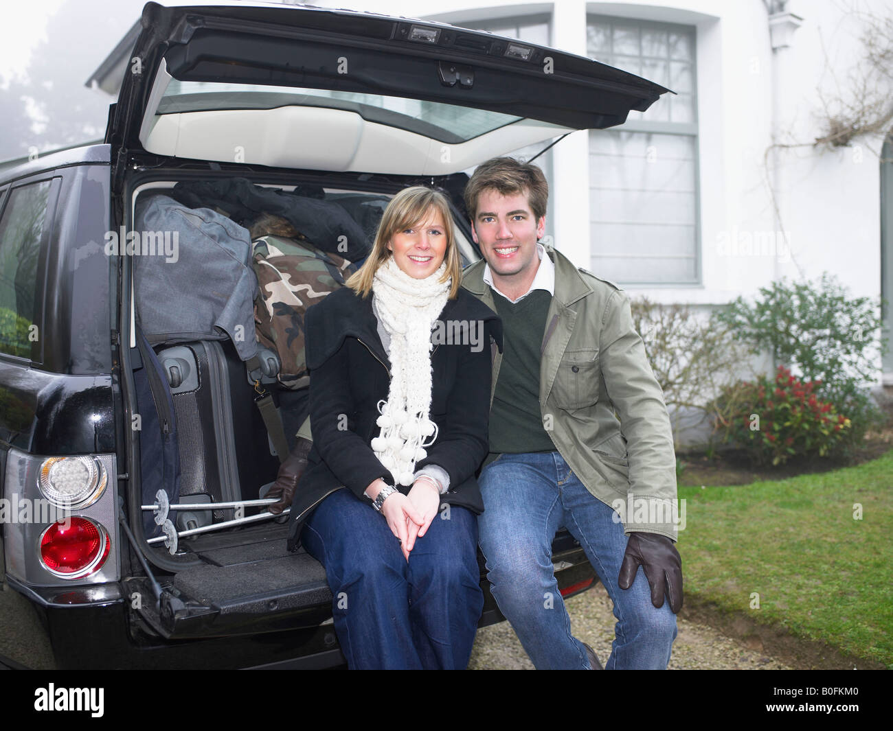 Couple in front of packed car Stock Photo - Alamy