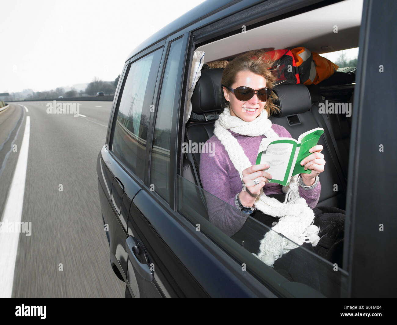 Young woman reading in car Stock Photo - Alamy