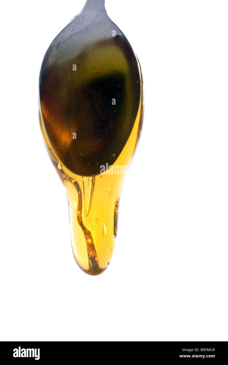 Sticky syrup dripping from a spoon Stock Photo - Alamy