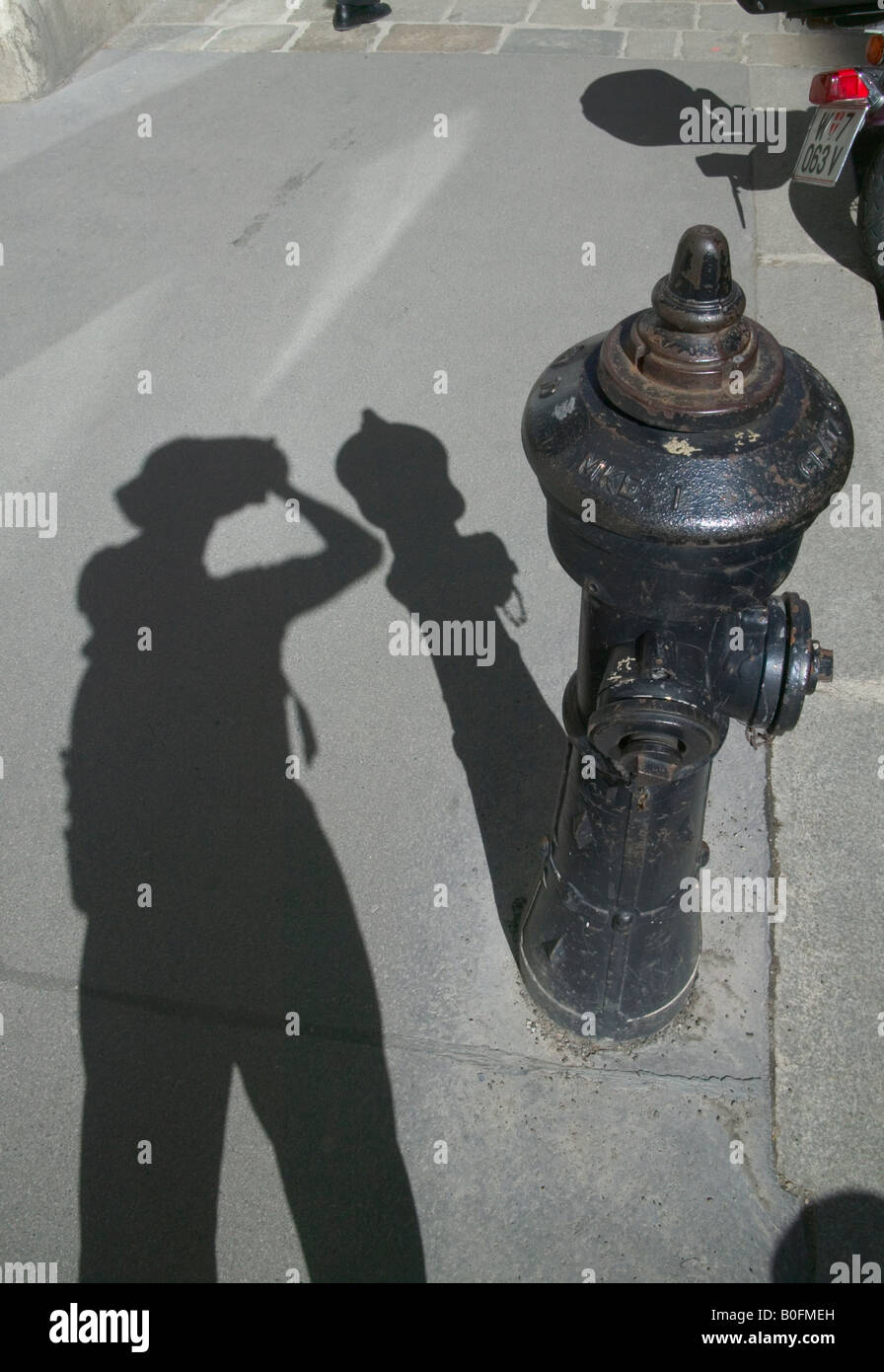 Shadow of tourist take picture with fire hydrant on the sidewalk Vienna ...