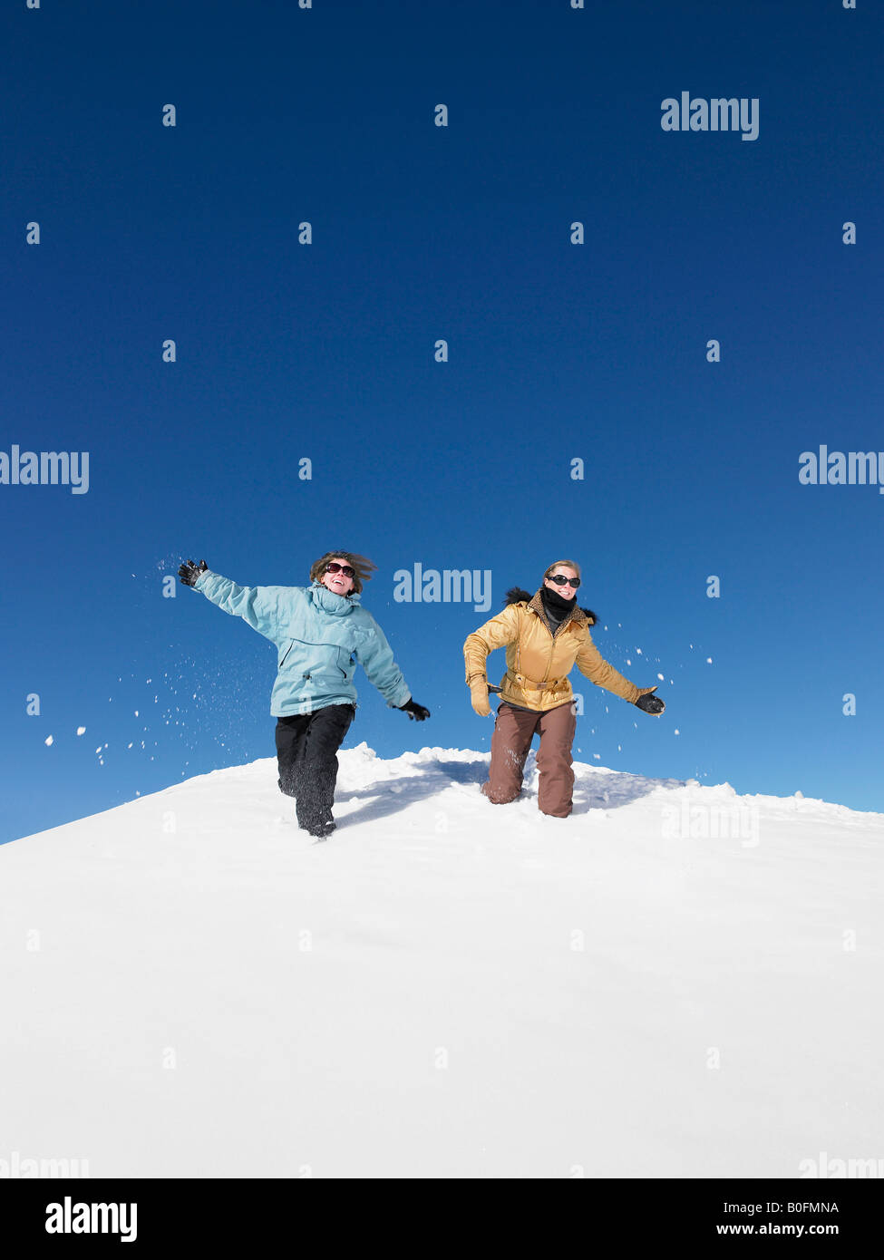 Young women running in snow Stock Photo - Alamy