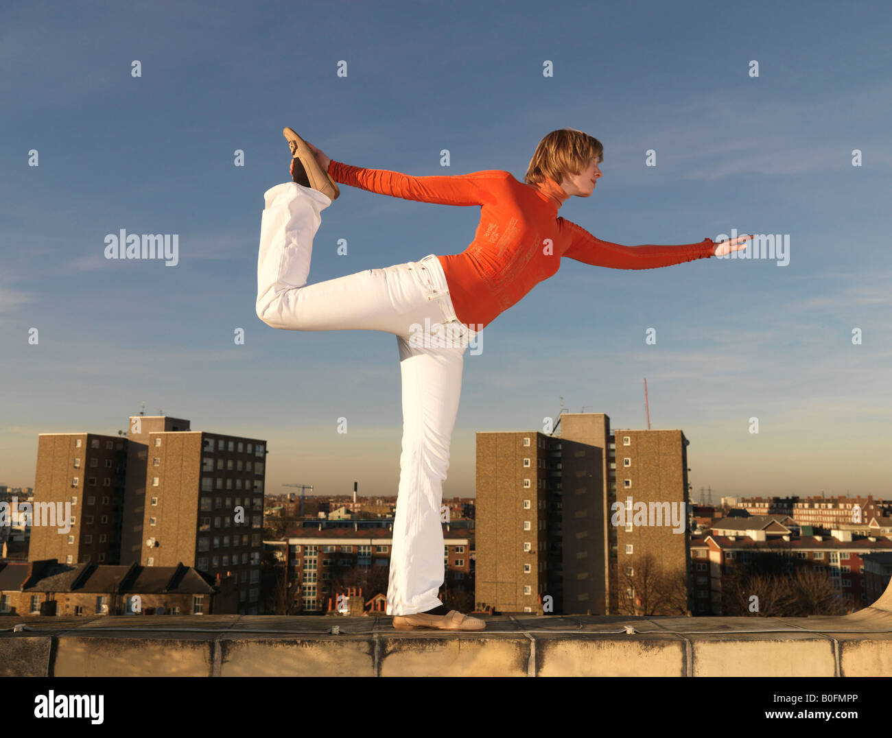 Woman balancing on roof terrace Stock Photo - Alamy