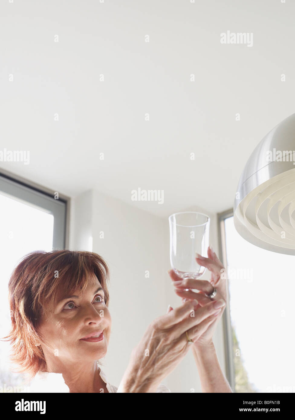 Senior woman inspecting glass Stock Photo - Alamy
