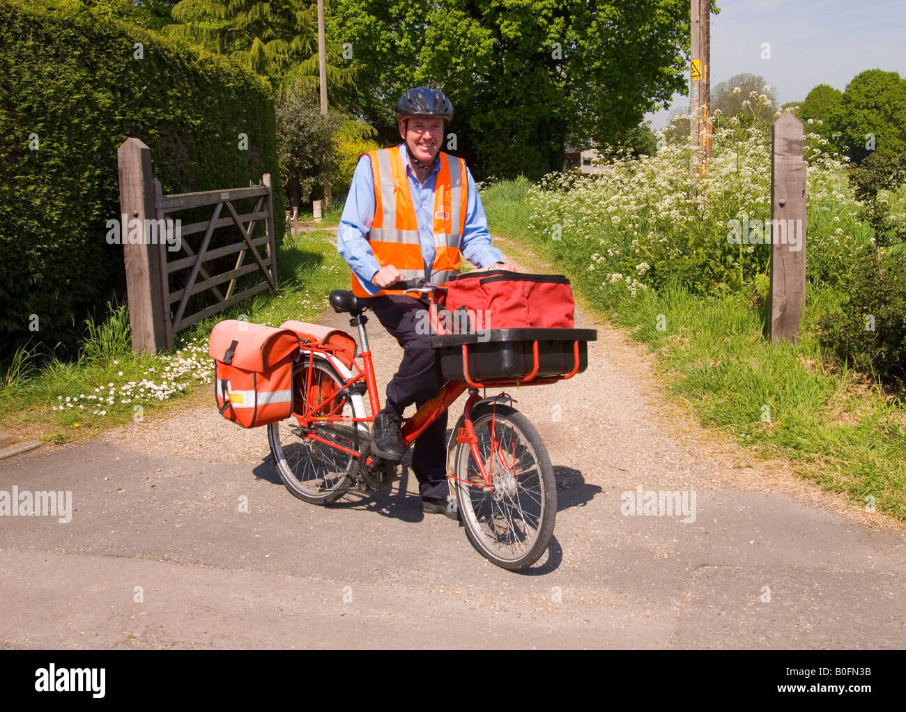 A Postman On His Round in the Uk in Spring Stock Photo - Alamy