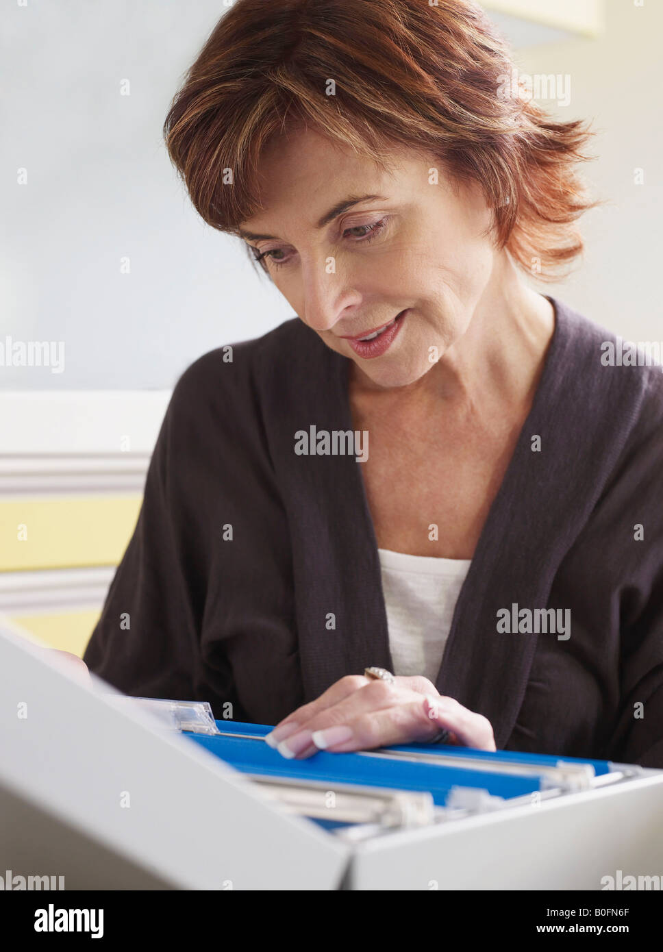 Senior woman looking through files Stock Photo - Alamy