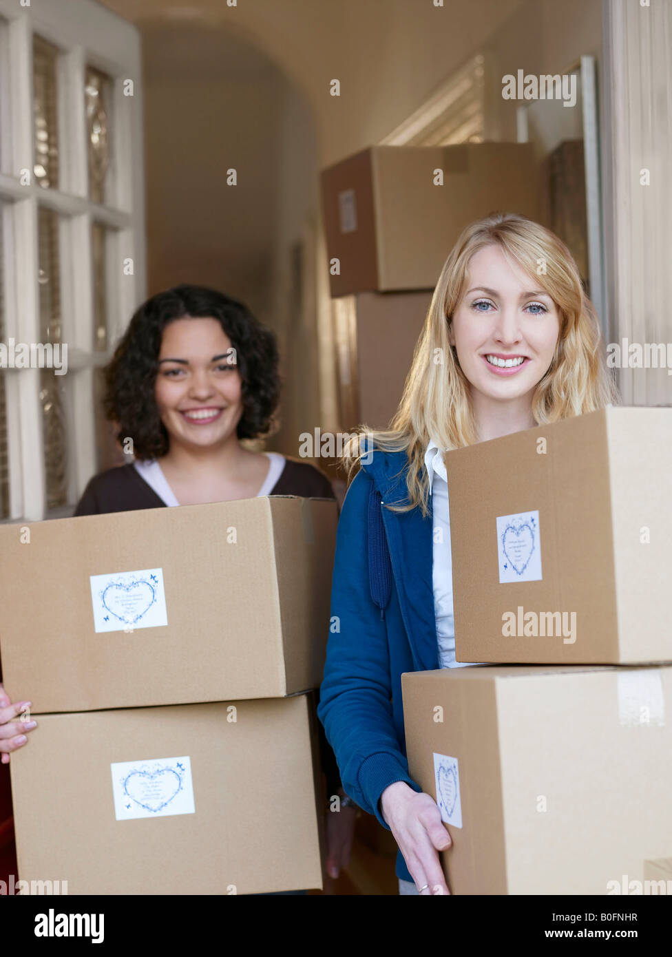 Women with boxes of goods in doorway Stock Photo - Alamy