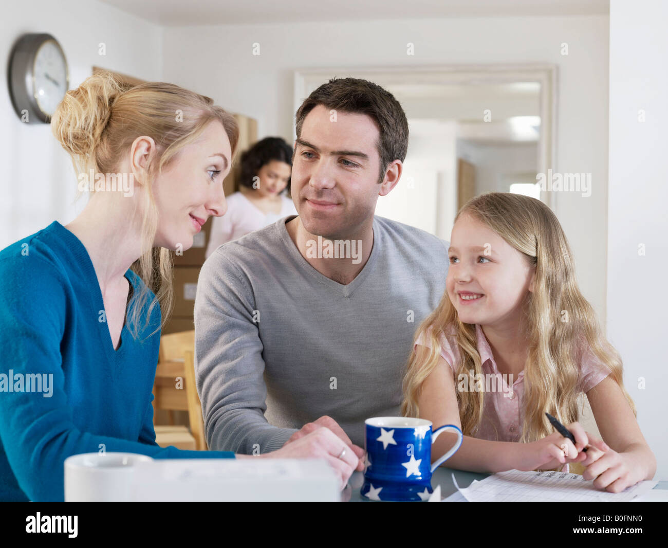 Family taking a break at kitchen table Stock Photo - Alamy