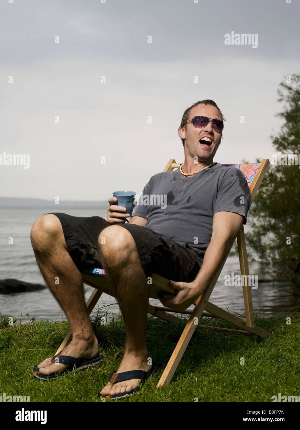 Man sitting in garden chair in the rain Stock Photo - Alamy