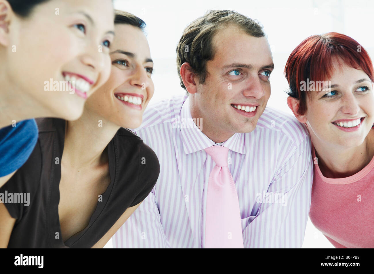 Four happy people looking off camera Stock Photo - Alamy