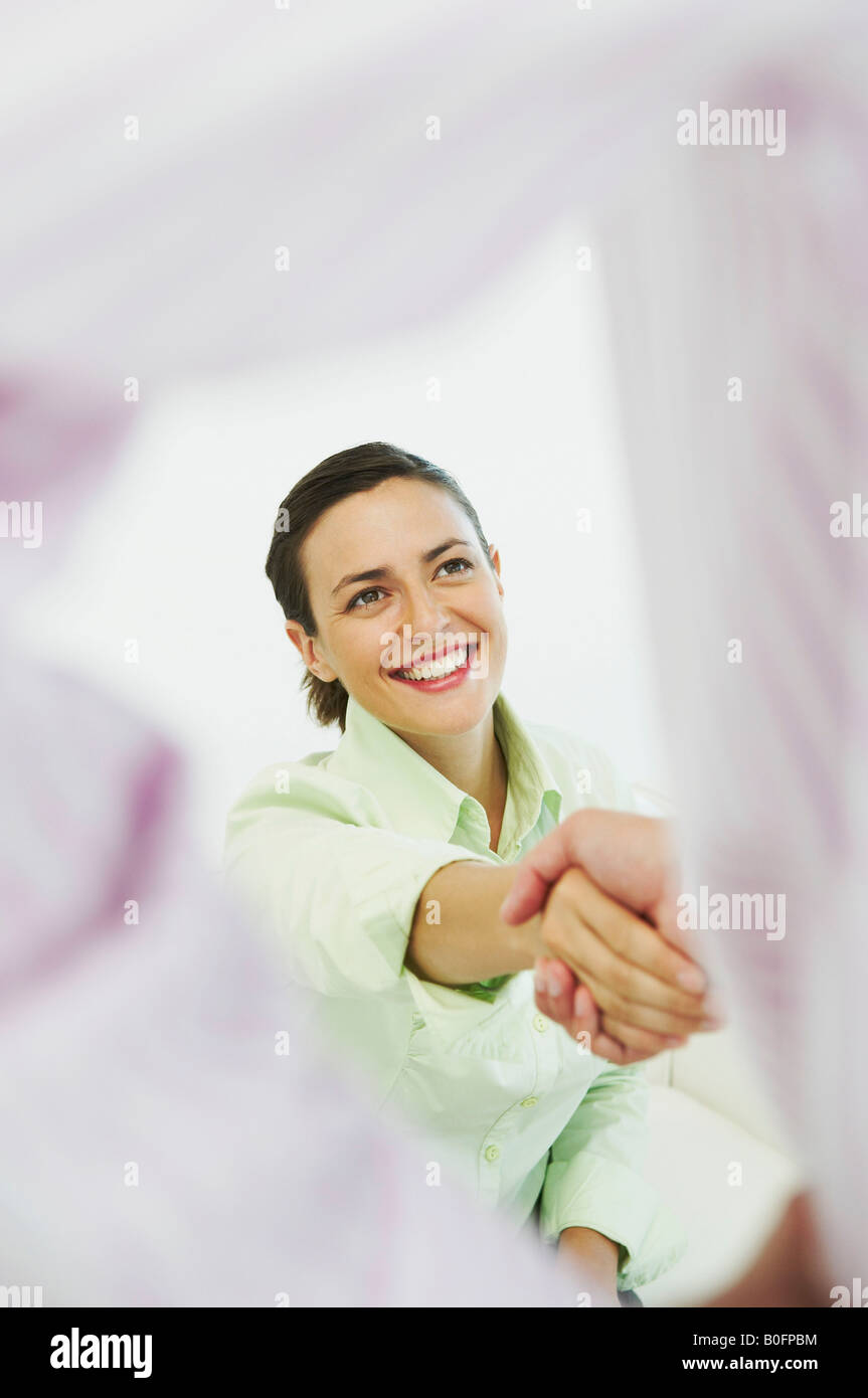 Smiling woman shaking hands Stock Photo - Alamy