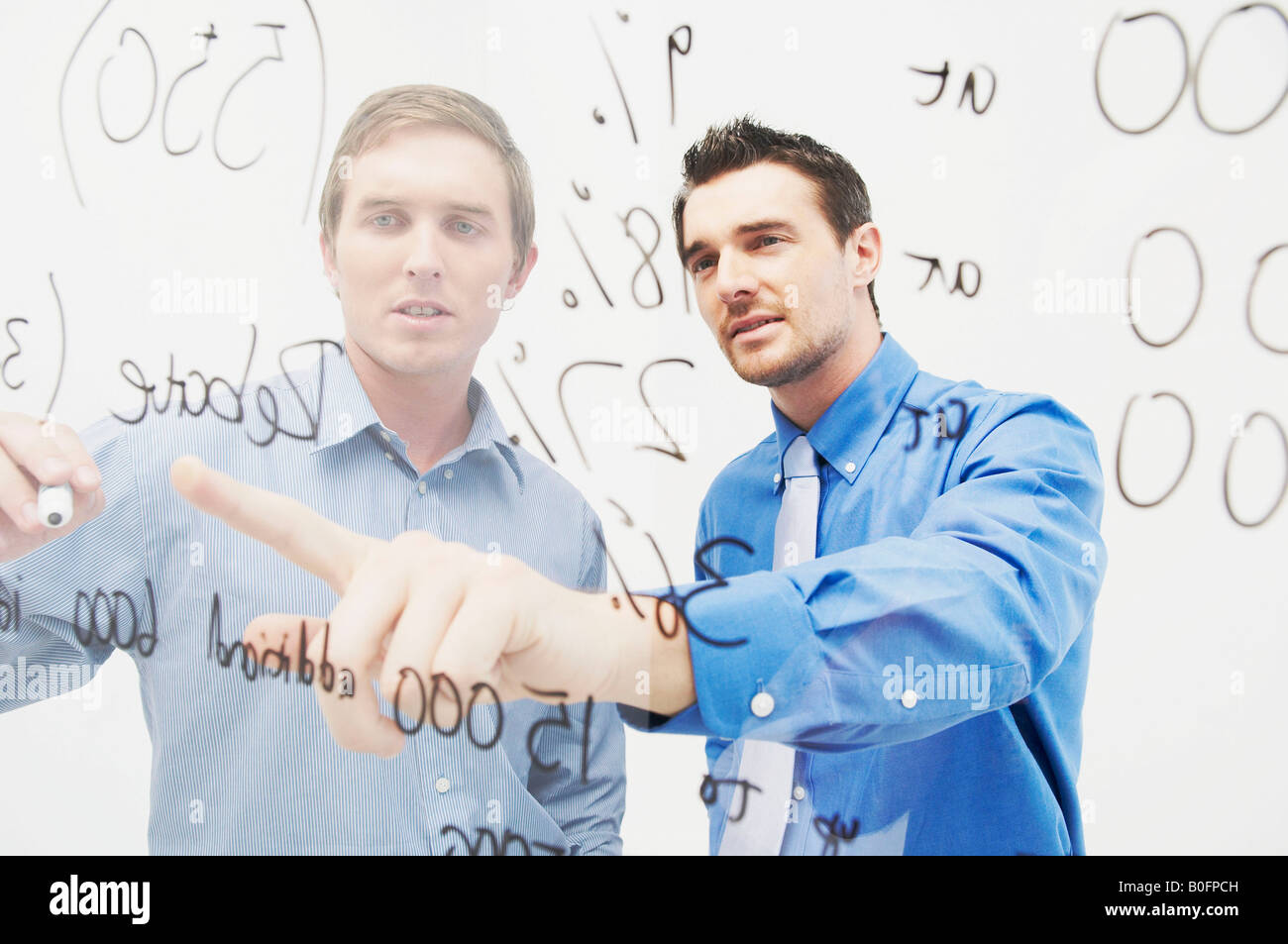 Two men write on glass panel Stock Photo - Alamy