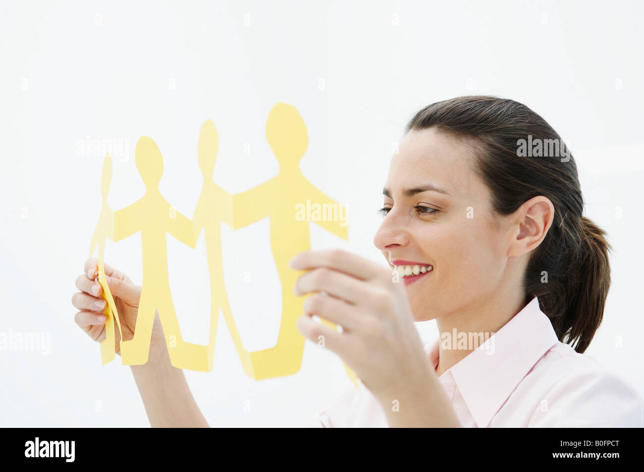 Smiling woman holds paper chain Stock Photo - Alamy