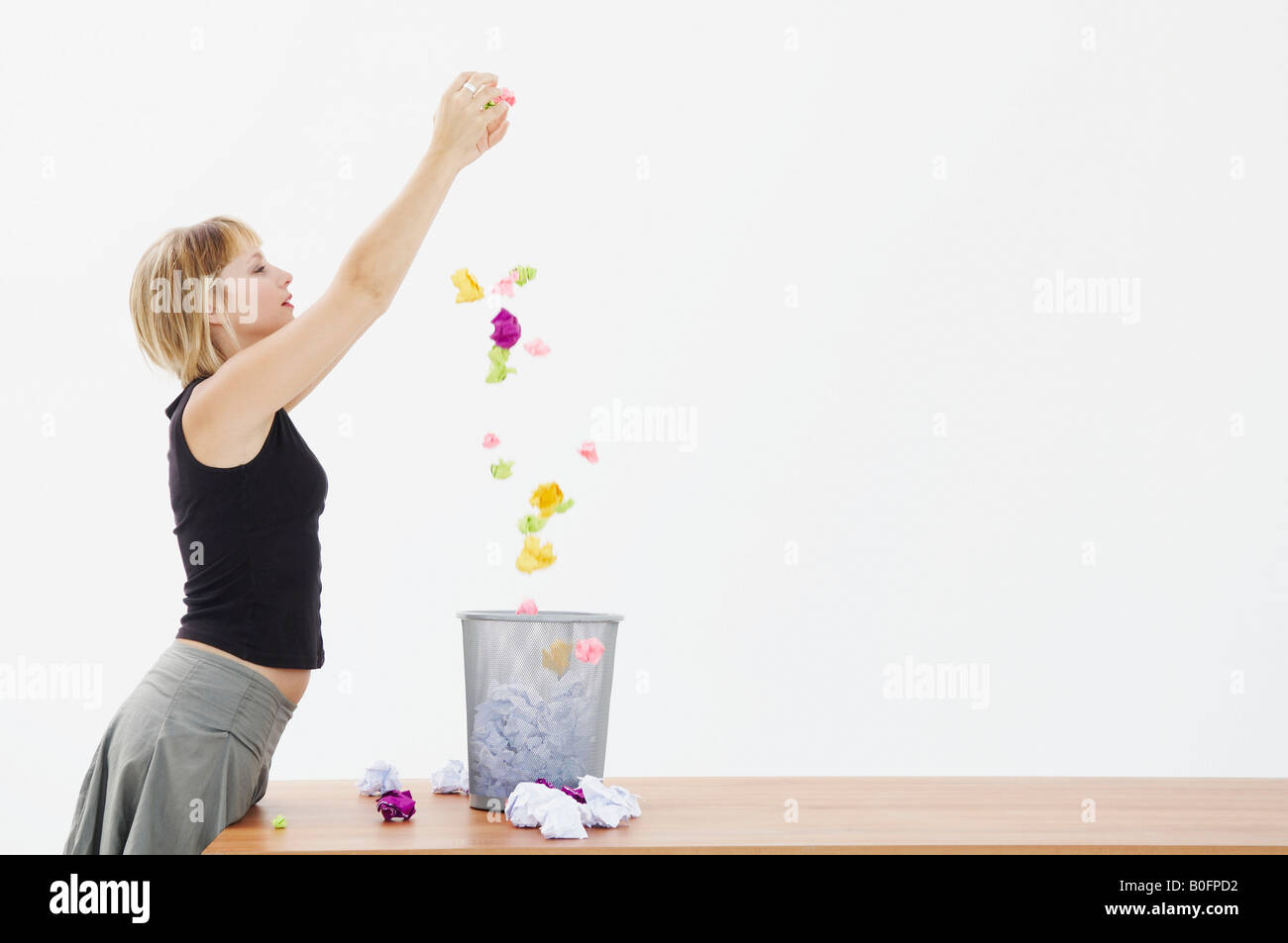 Woman drops paper into bin Stock Photo - Alamy