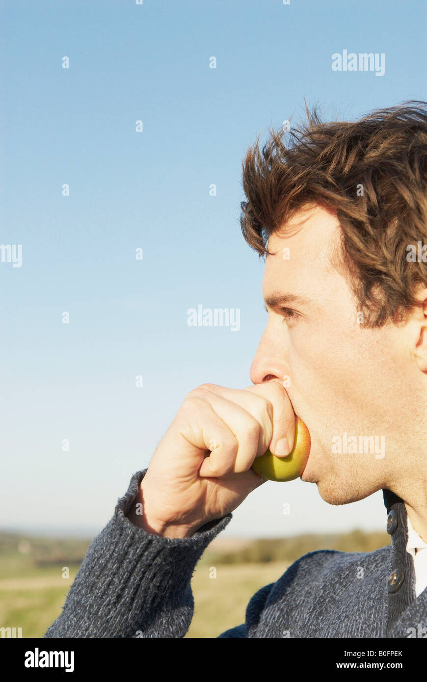 Man eating apple in countryside Stock Photo - Alamy