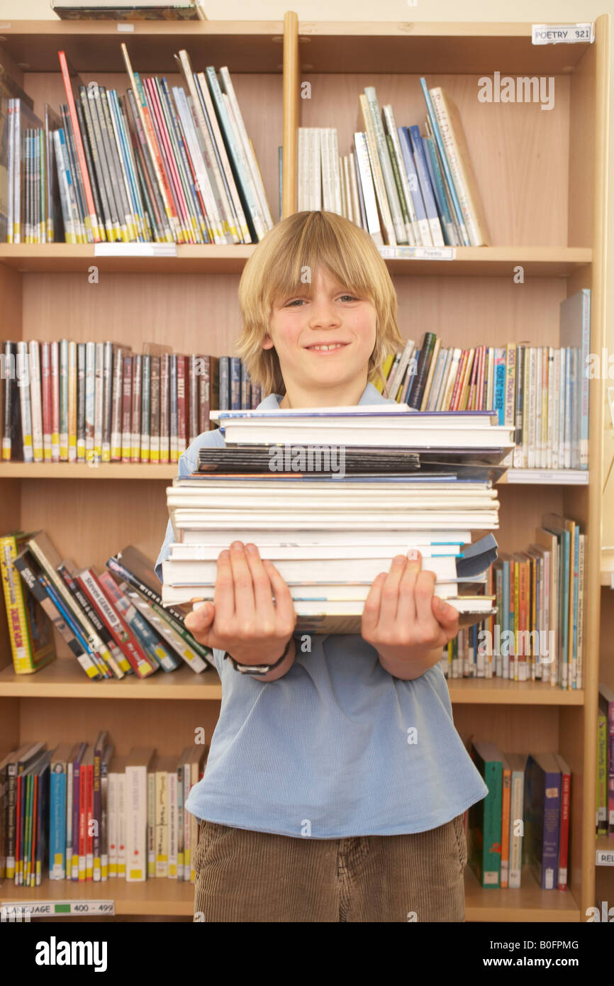 Boy carrying books, smiling Stock Photo - Alamy