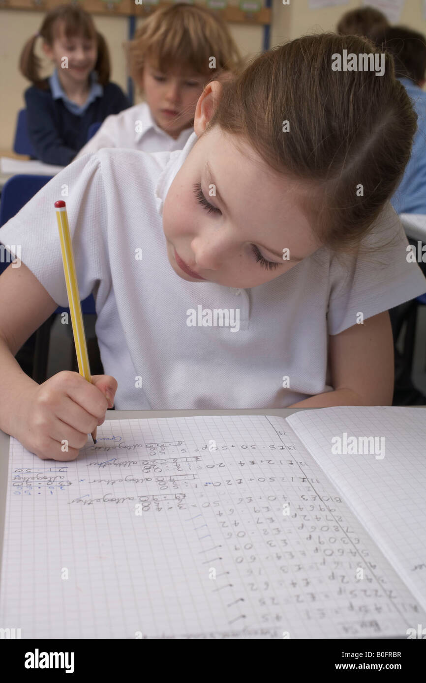 Girl writing in classroom Stock Photo - Alamy